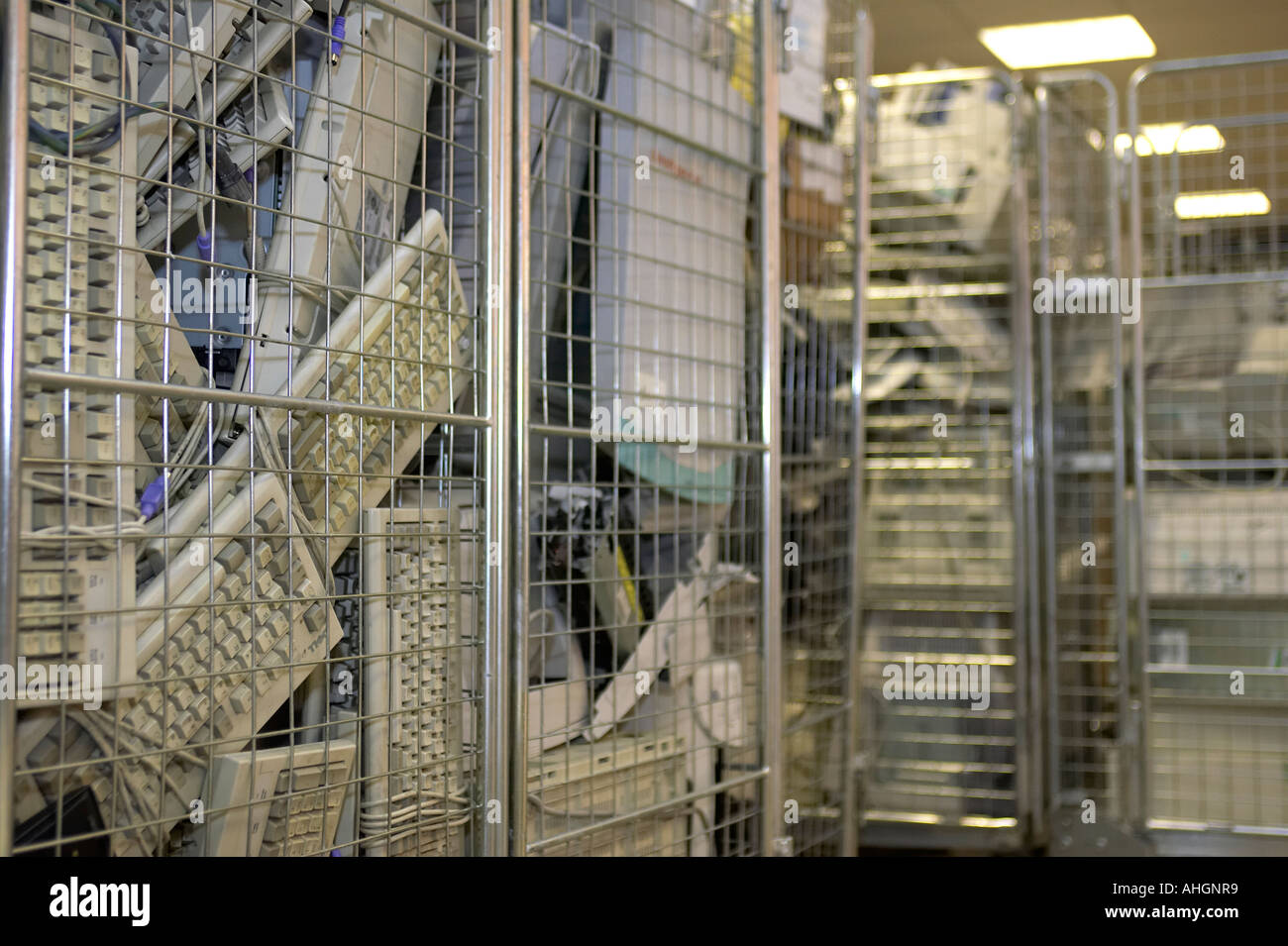 Steel cage containers containing piles of old computer components ...