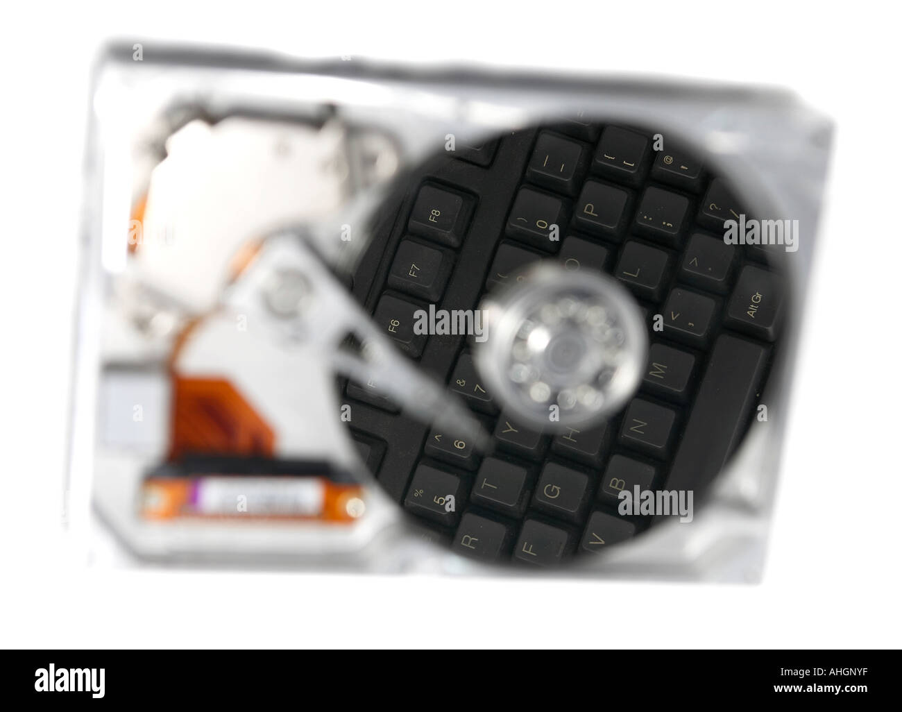 keyboard reflected in disc of open broken hard drive against white ...