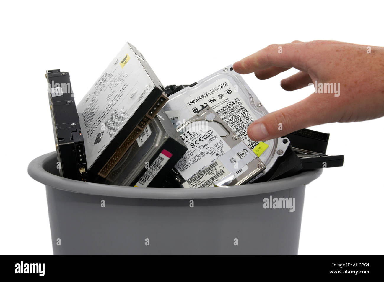 hand reaching for used hard drive in grey bin containing various ...