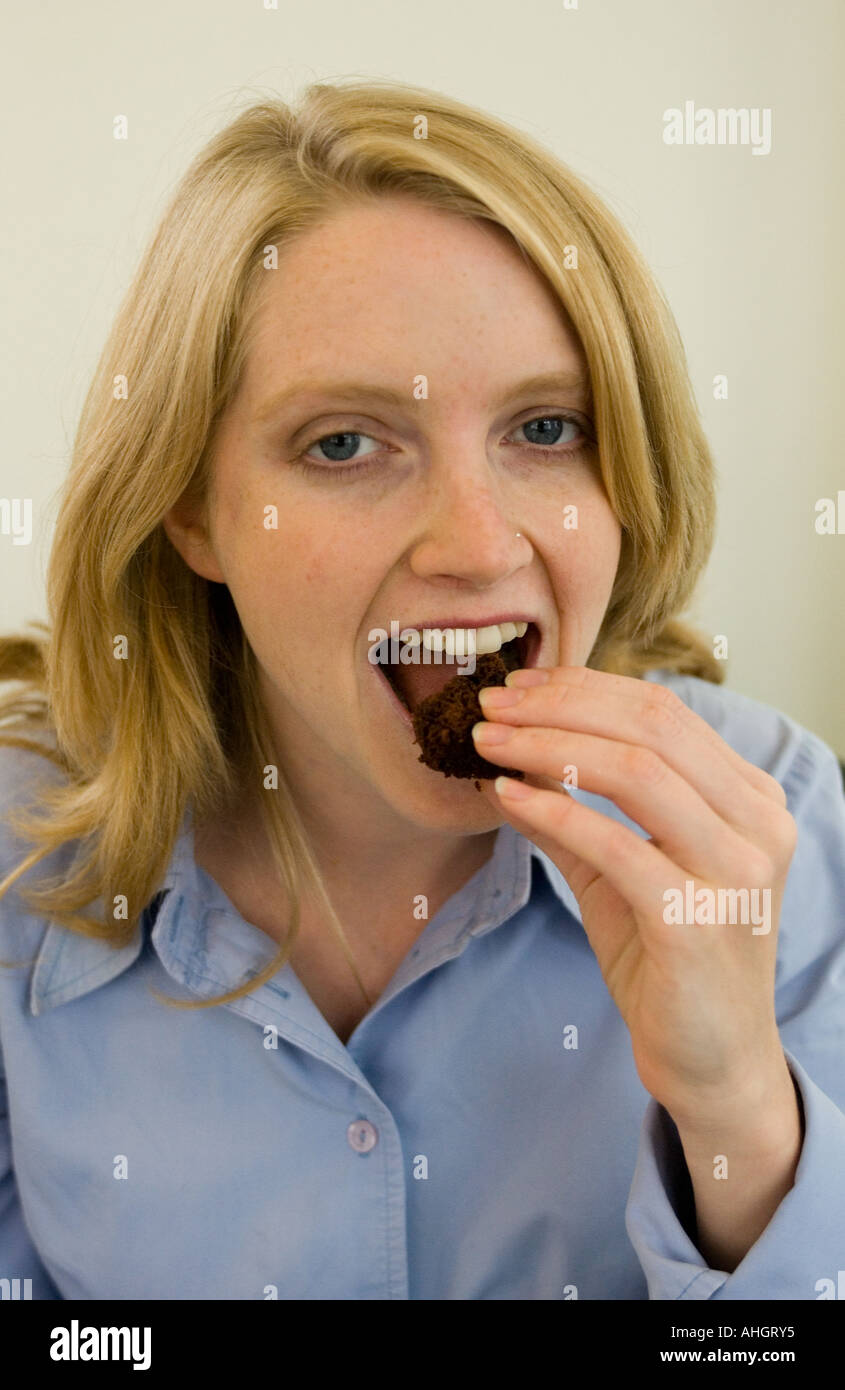 Office worker eating a Fairtrade snack Stock Photo - Alamy