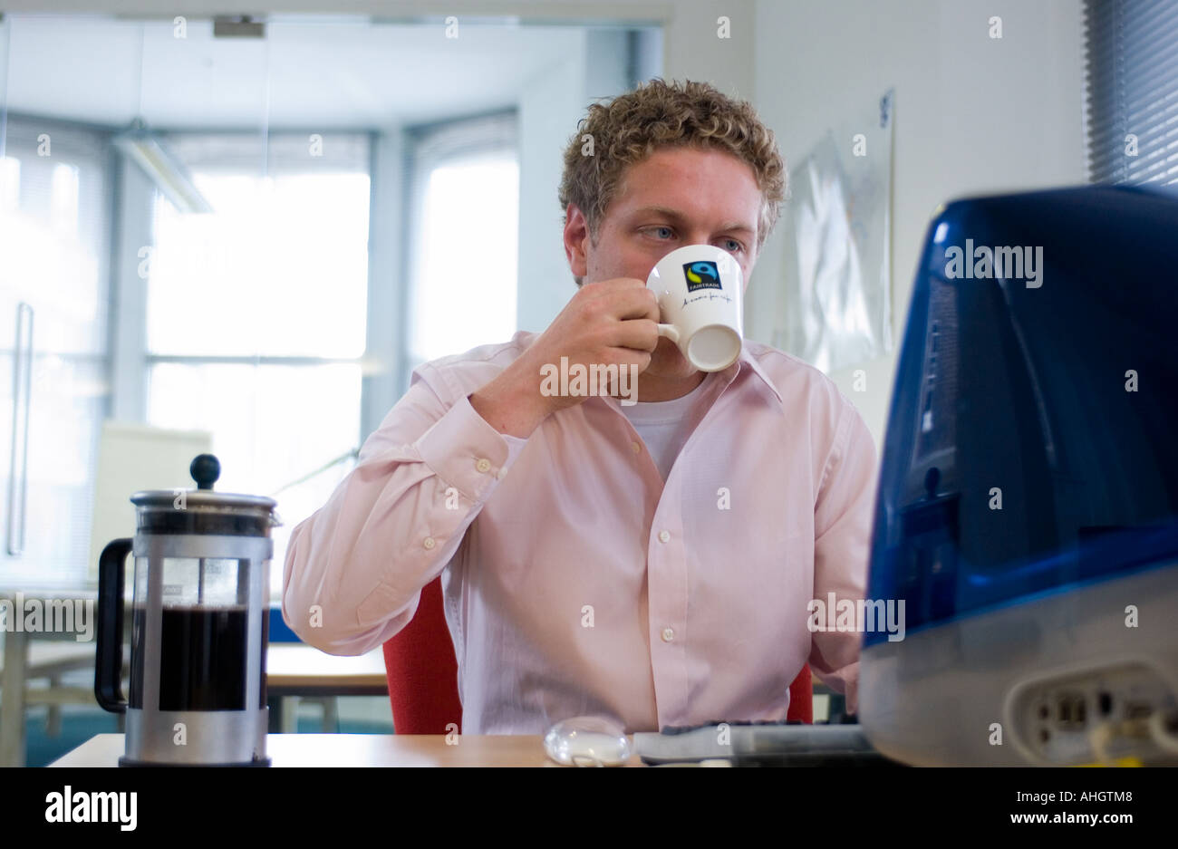 Office worker drinking a cup of Fairtrade coffee Stock Photo - Alamy