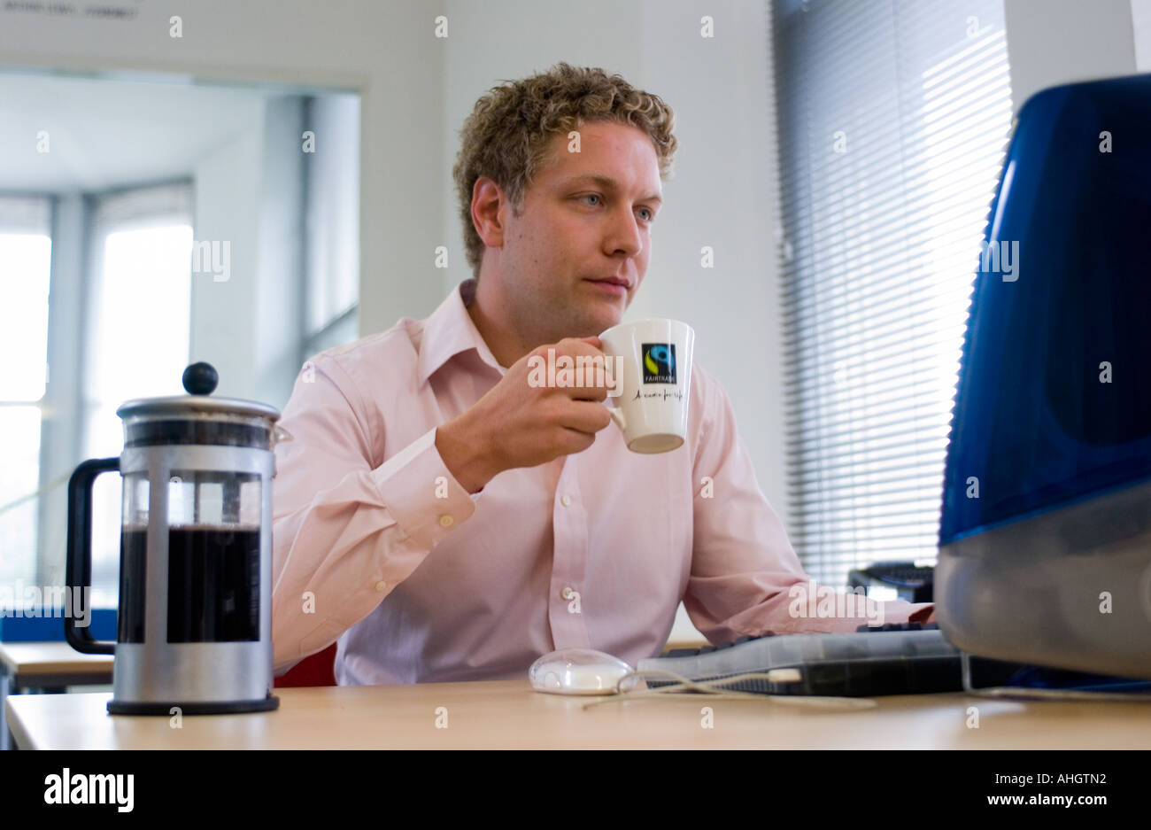 Office worker drinking a cup of Fairtrade coffee Stock Photo - Alamy