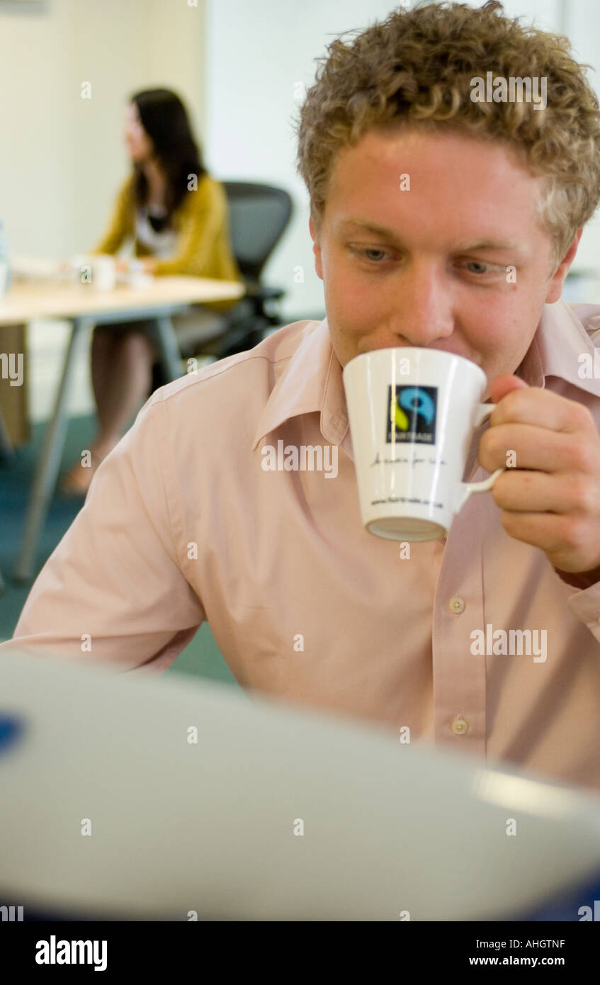 Office worker drinking a cup of Fairtrade coffee Stock Photo - Alamy