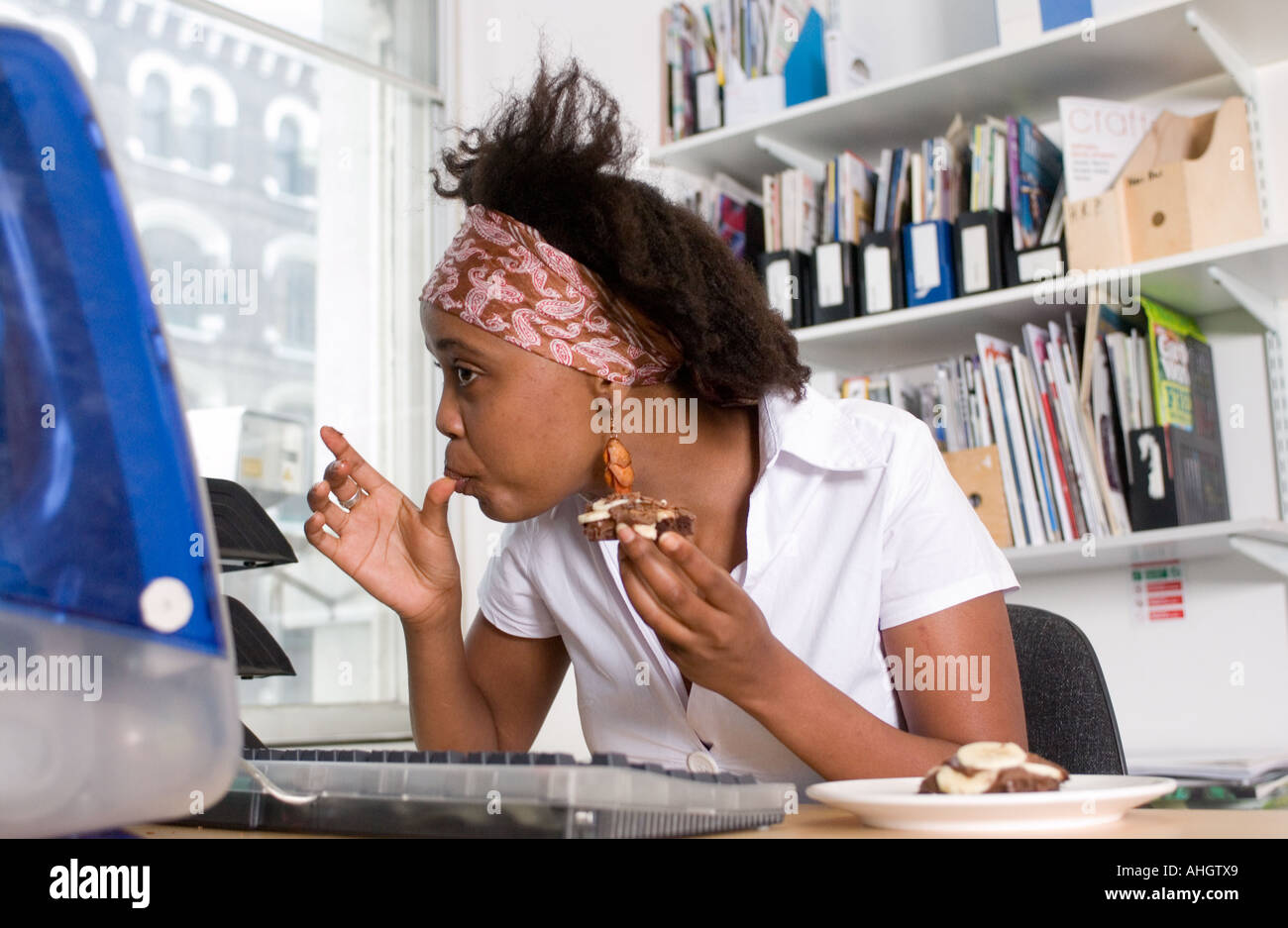 Office worker eating a Fairtrade snack Stock Photo - Alamy