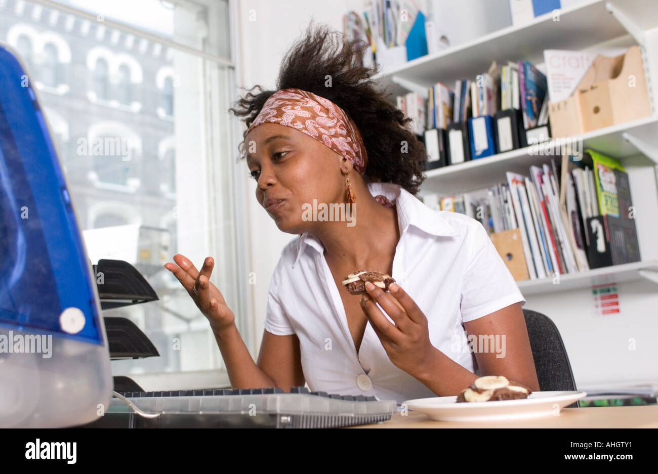 Office worker eating a Fairtrade snack Stock Photo - Alamy