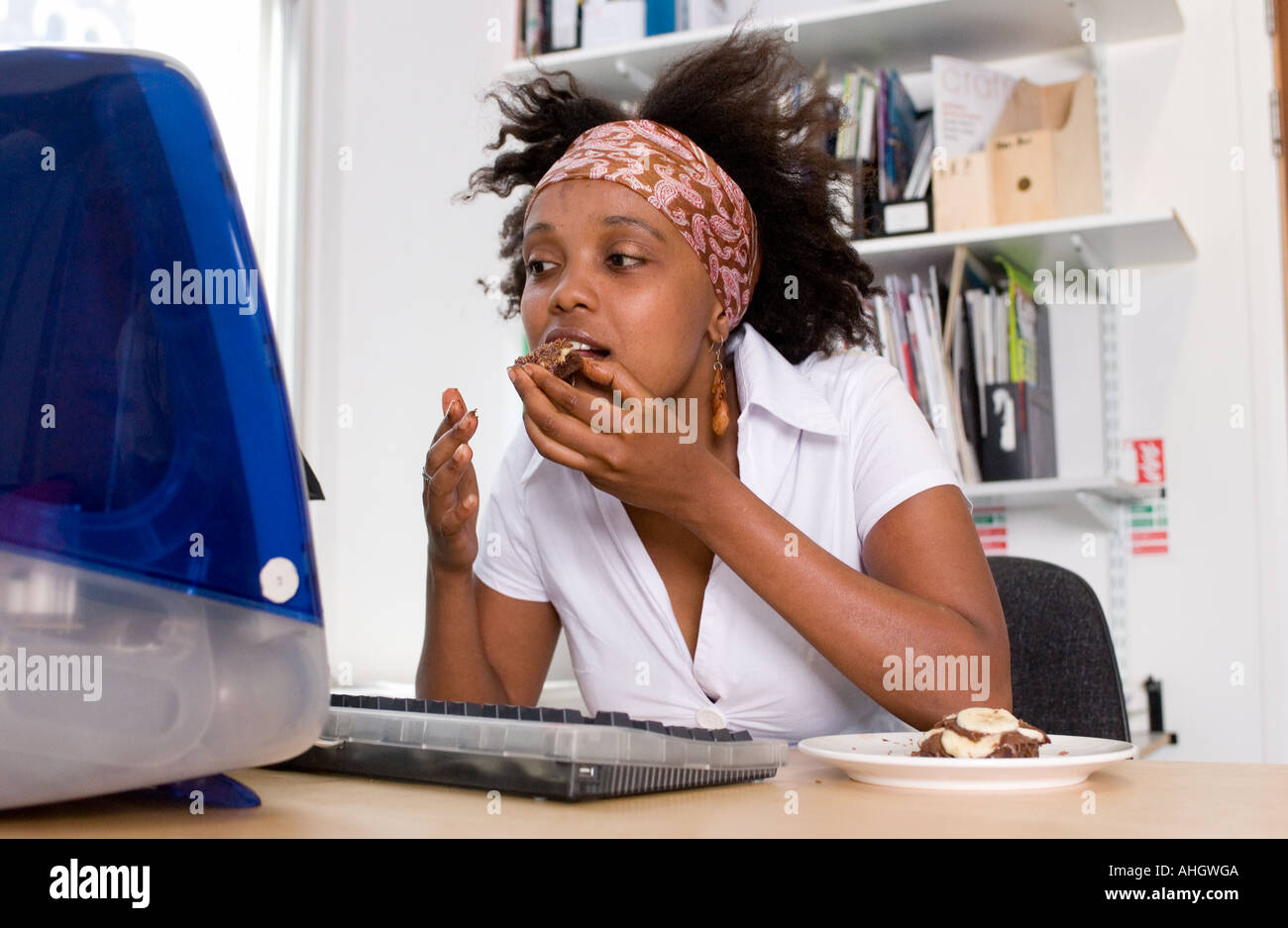 Office worker eating a Fairtrade snack Stock Photo - Alamy