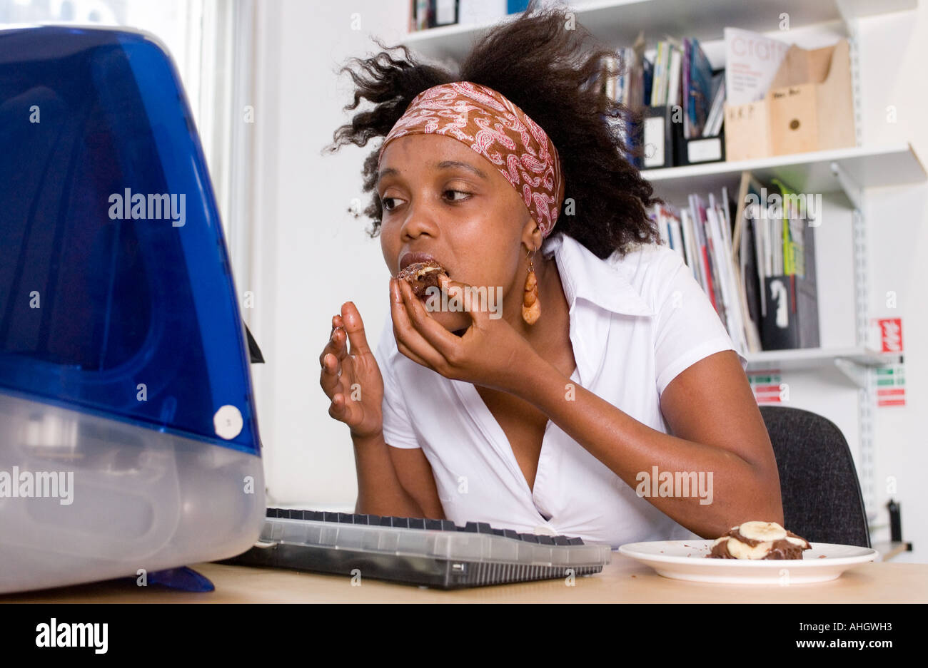 Office worker eating a Fairtrade snack Stock Photo - Alamy