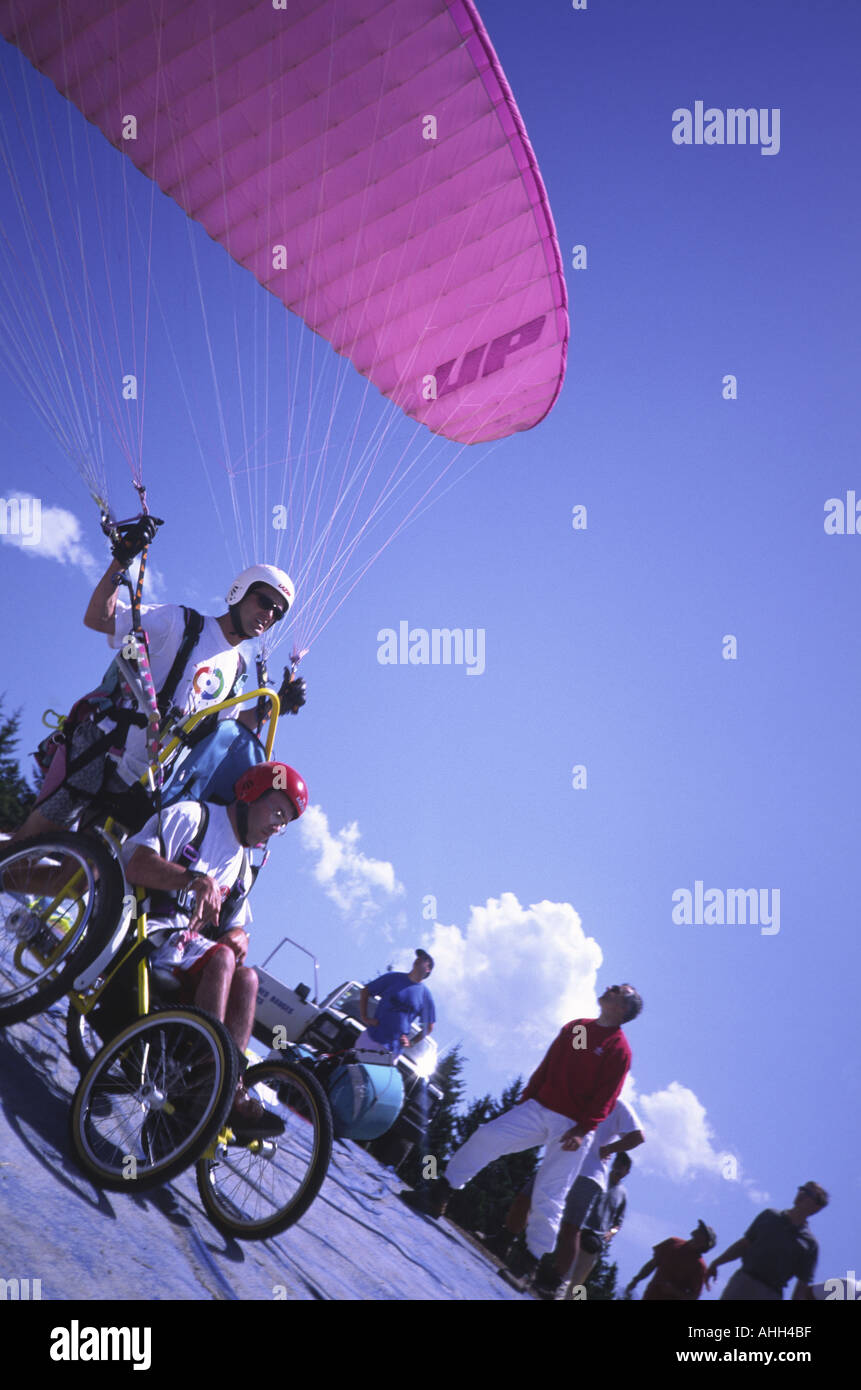 paraglider pilot taking off with a disabled passenger in a specialy ...