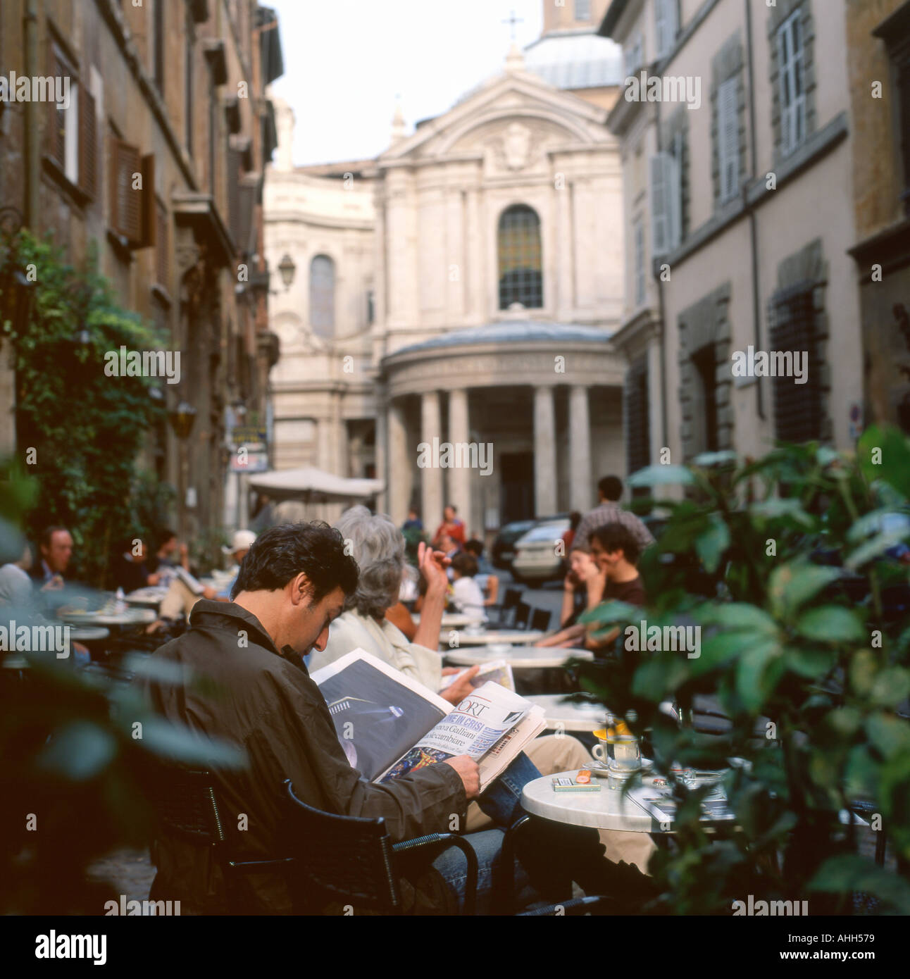 Man reading newspaper and drinking coffee at an at an outdoor cafe Rome ...
