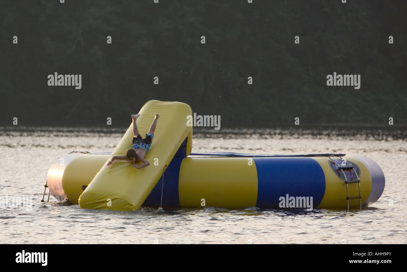 Boys playing on an inflatable raft on a lake Stock Photo - Alamy