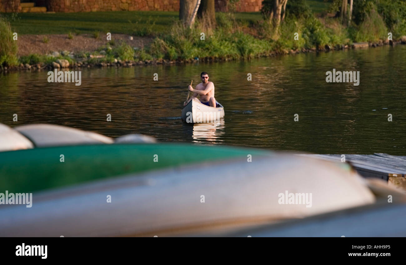 Man paddling a canoe on a lake Stock Photo - Alamy