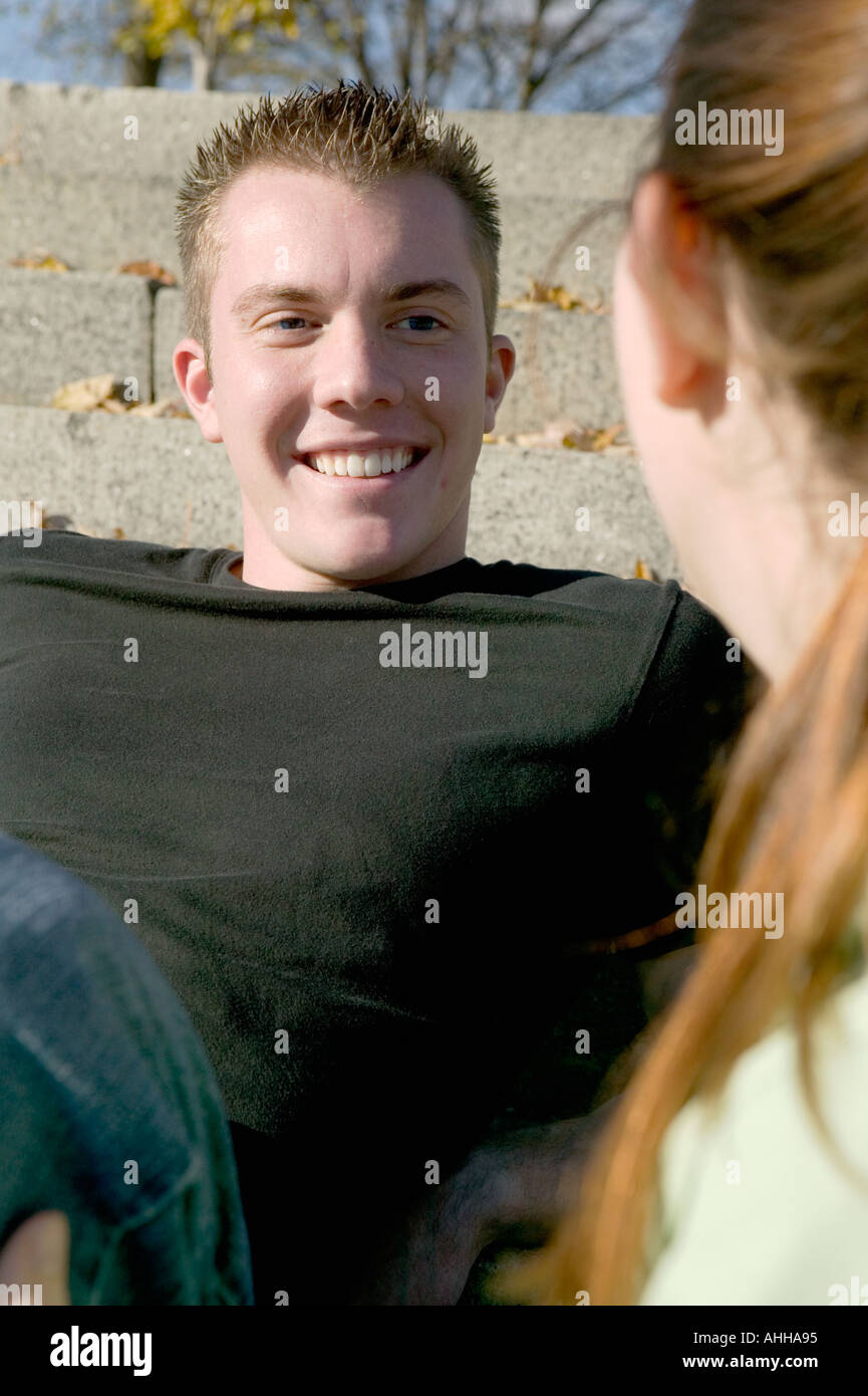 Young guy and girl talking outside Stock Photo - Alamy