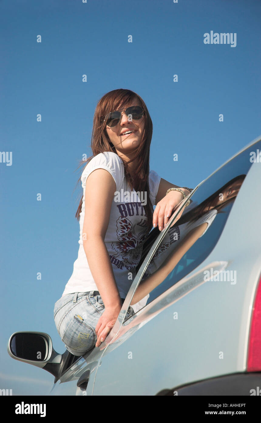 Young woman hanging out of car window side view Stock Photo - Alamy