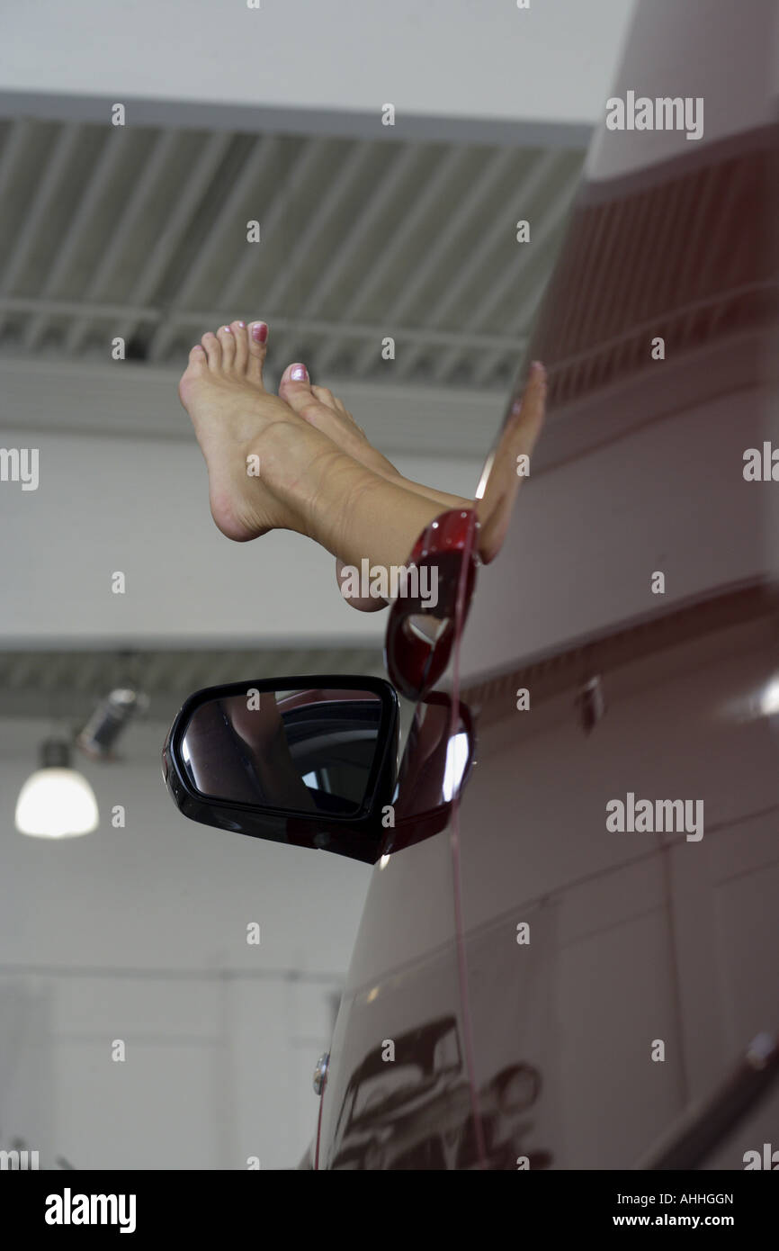 young woman holding her feet out of car window Stock Photo - Alamy