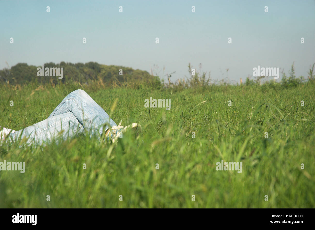 Young woman lying on field low section Stock Photo - Alamy