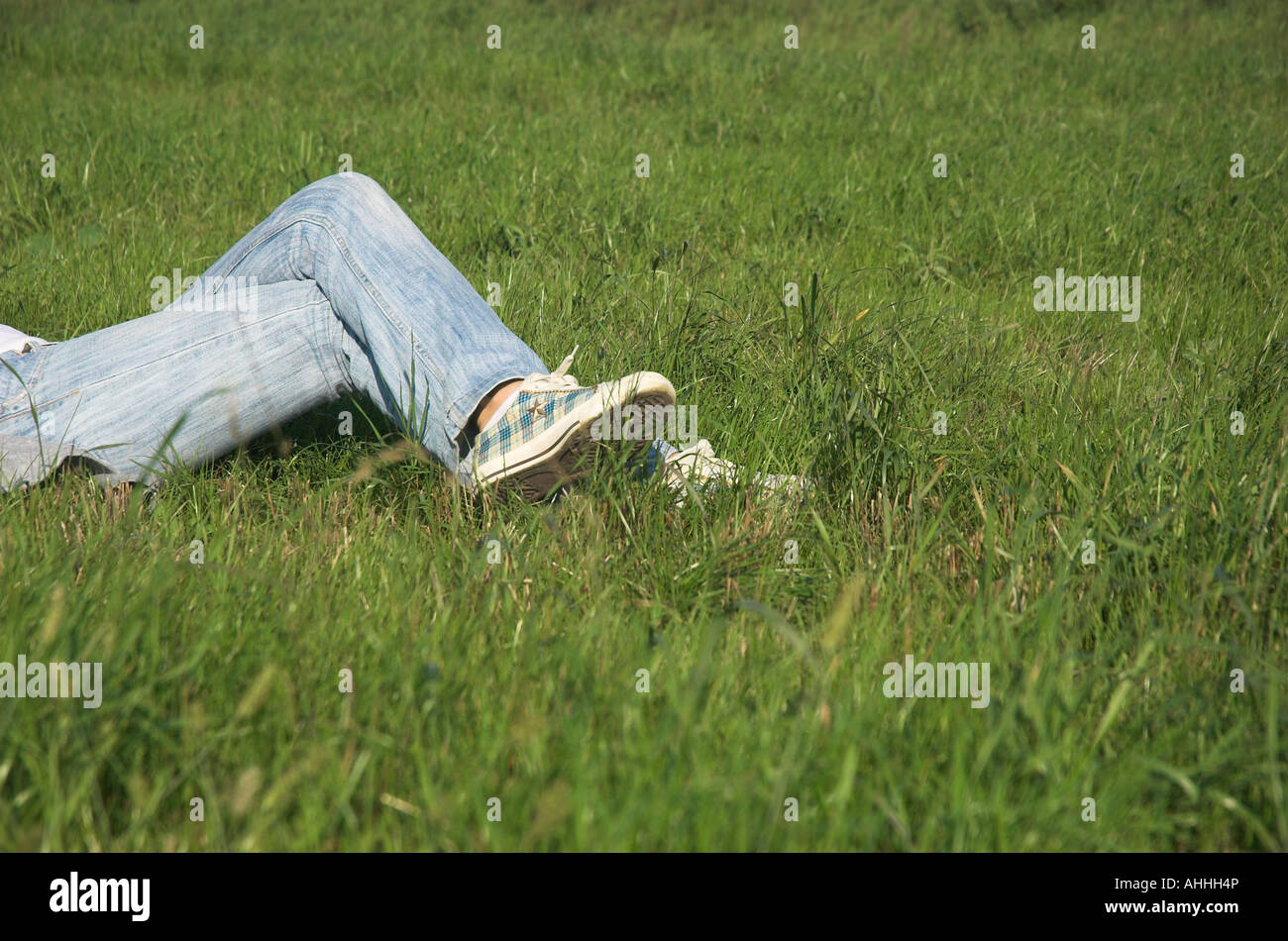 Young woman lying on field low section Stock Photo - Alamy