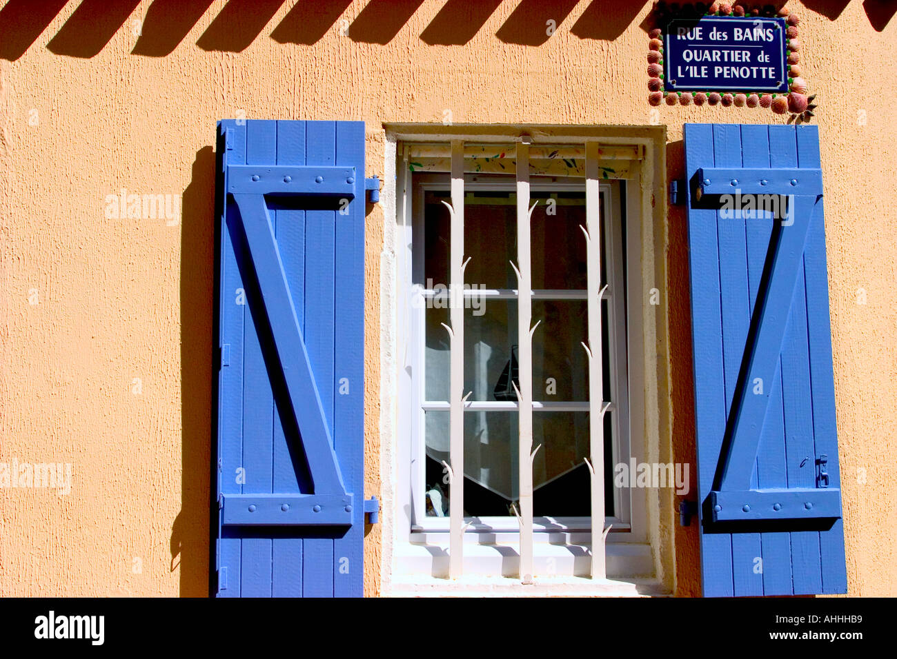 wall frontage of house with white windows and blue shutters with open ...