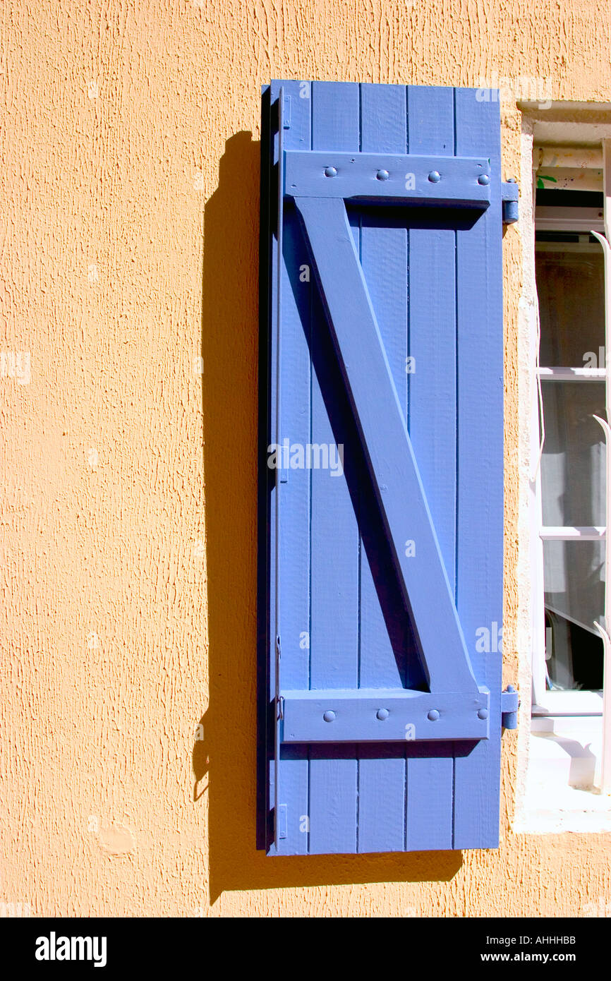 wall frontage of house with white windows and blue shutters with open ...