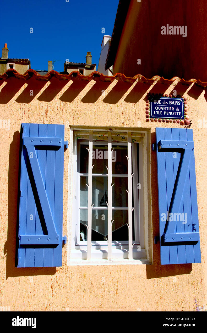 wall frontage of house with white windows and blue shutters with open ...