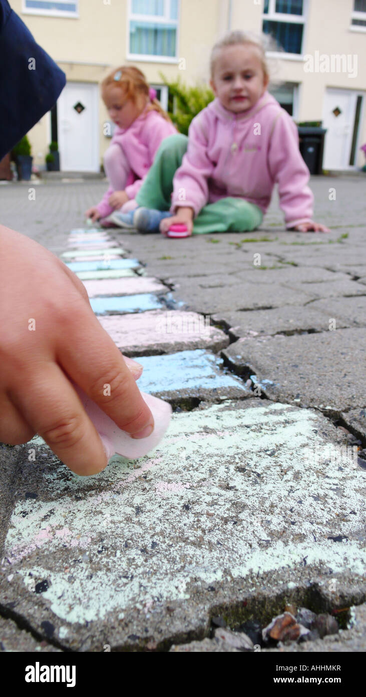 children are painting paving stones with street crayon Stock Photo - Alamy