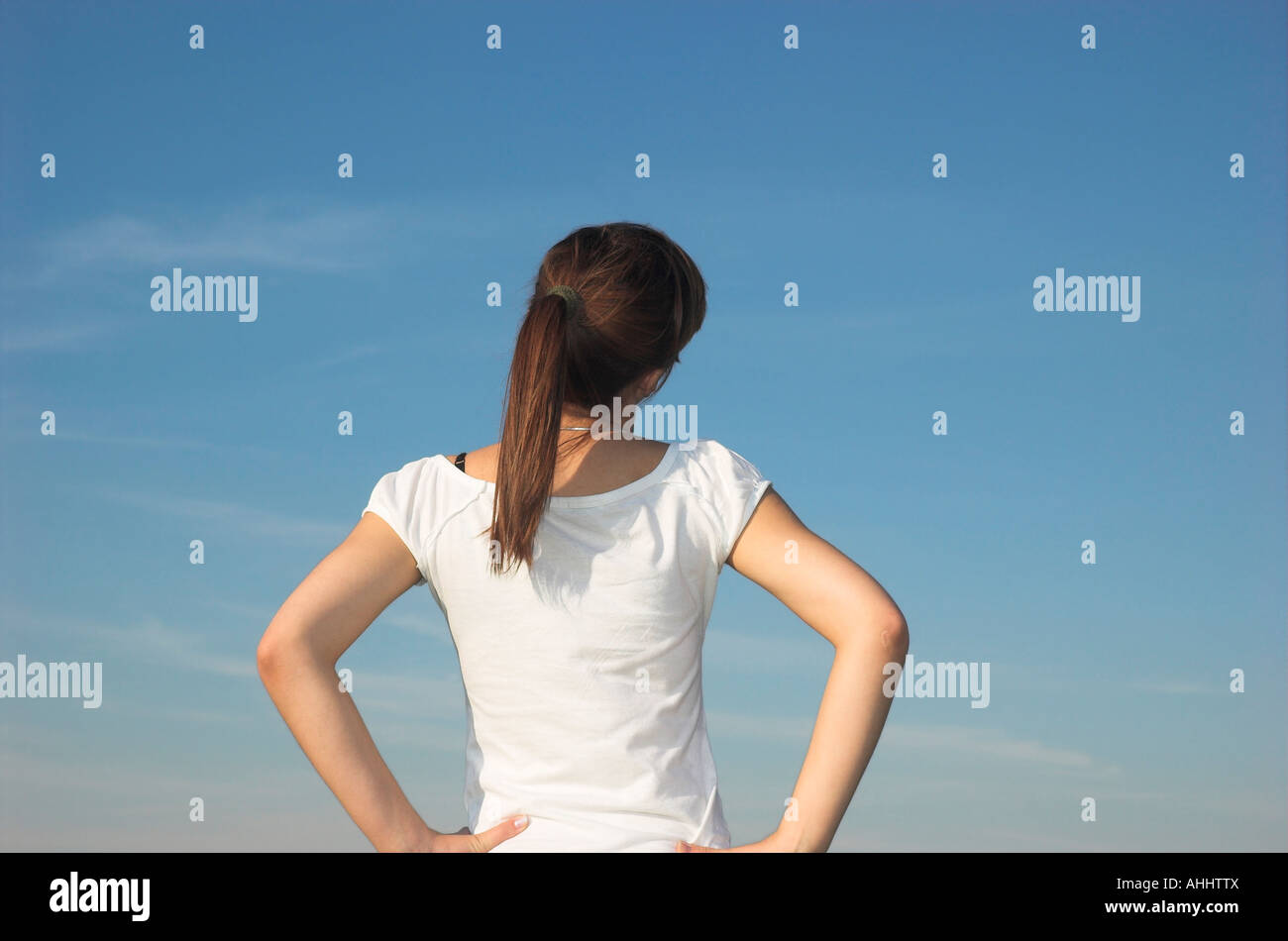 Young woman standing outdoors looking at distance rear view Stock Photo ...