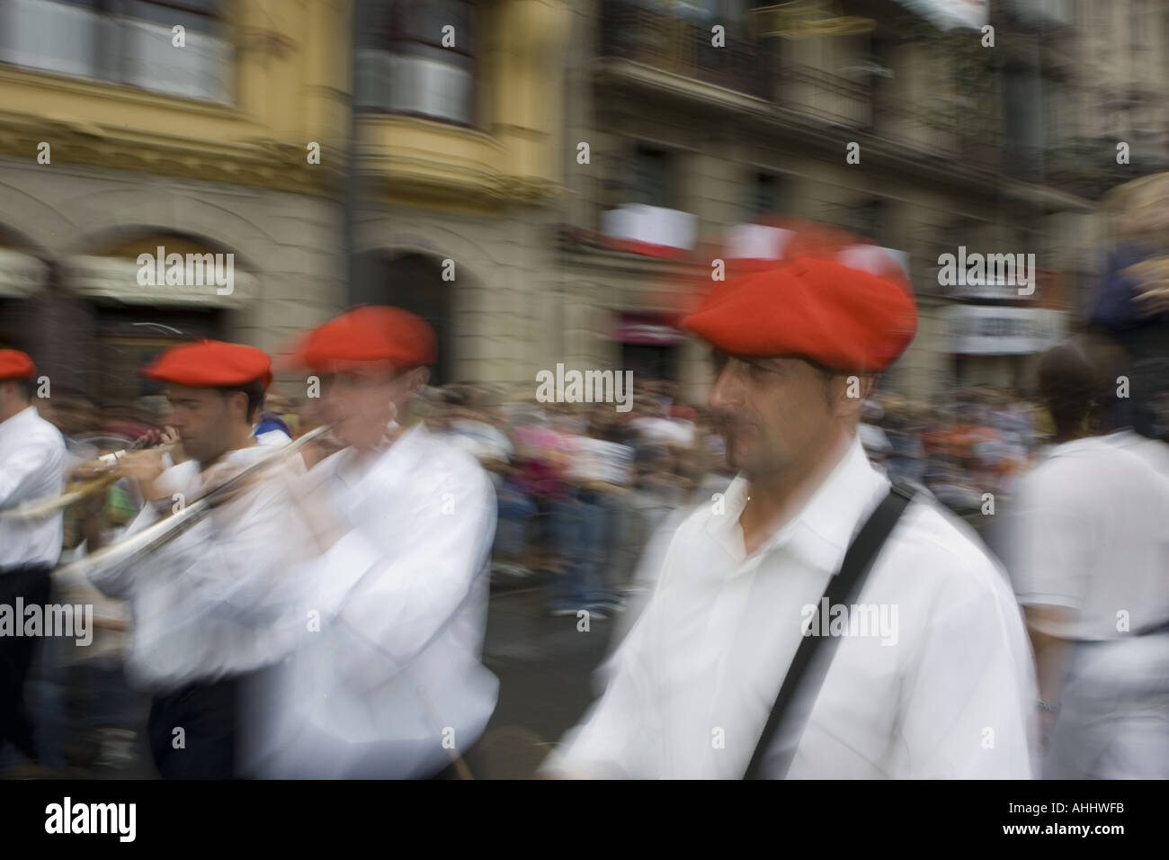 Members of a traditional Basque band wearing red berets parade through ...