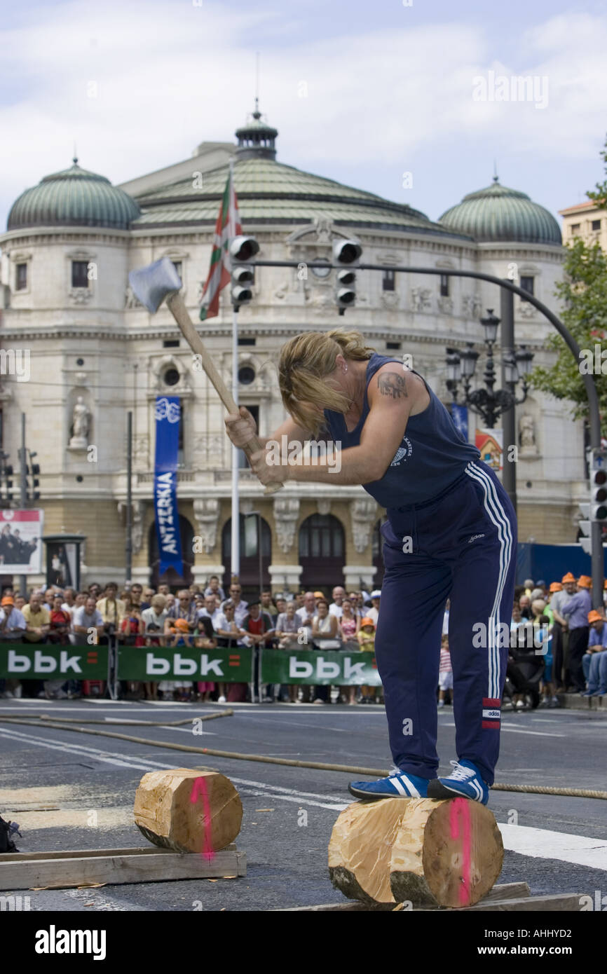 Woman competing in wood chopping contest during Basque Strong Man games ...
