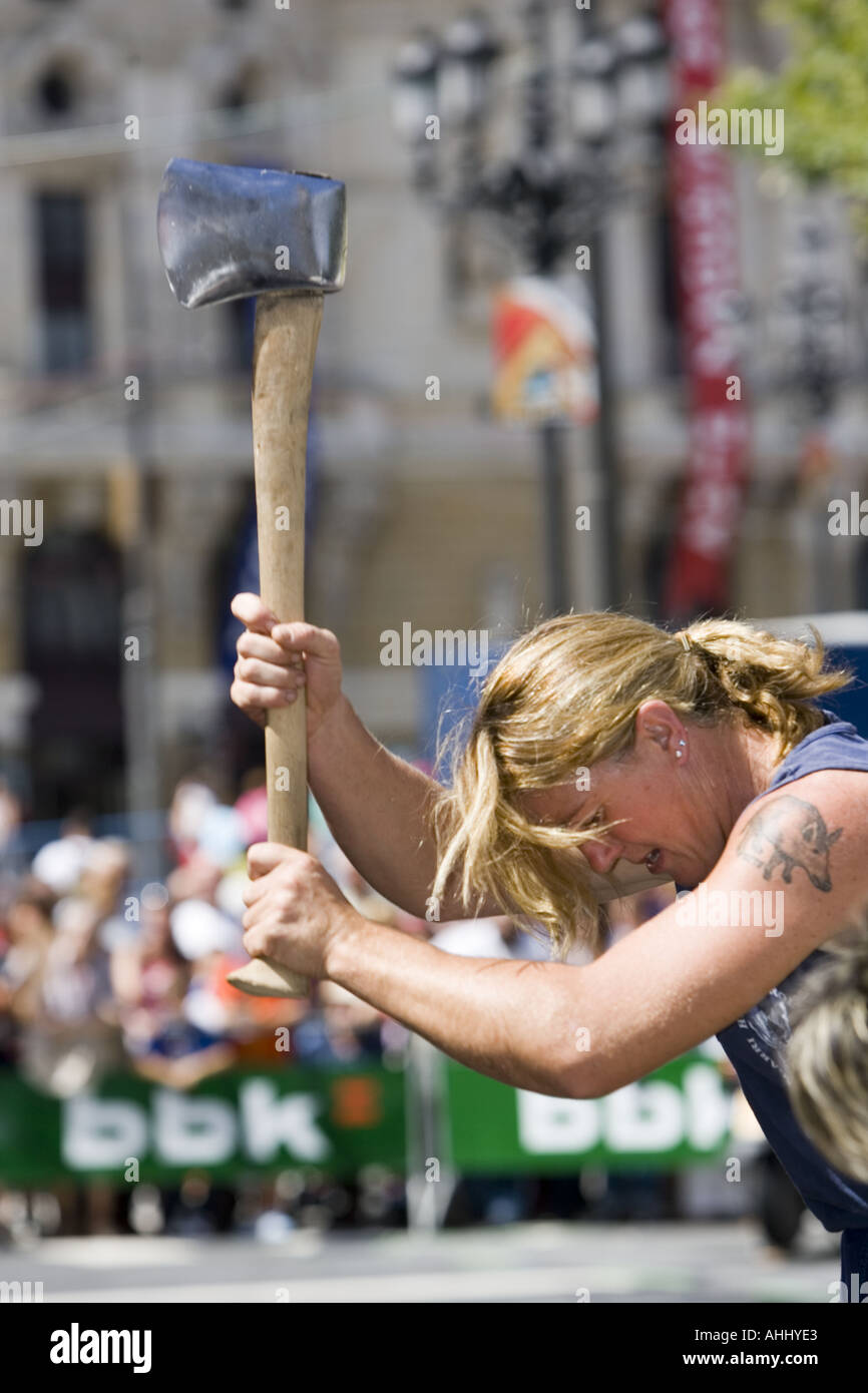 Woman competing in wood chopping contest during Basque Strong Man games ...
