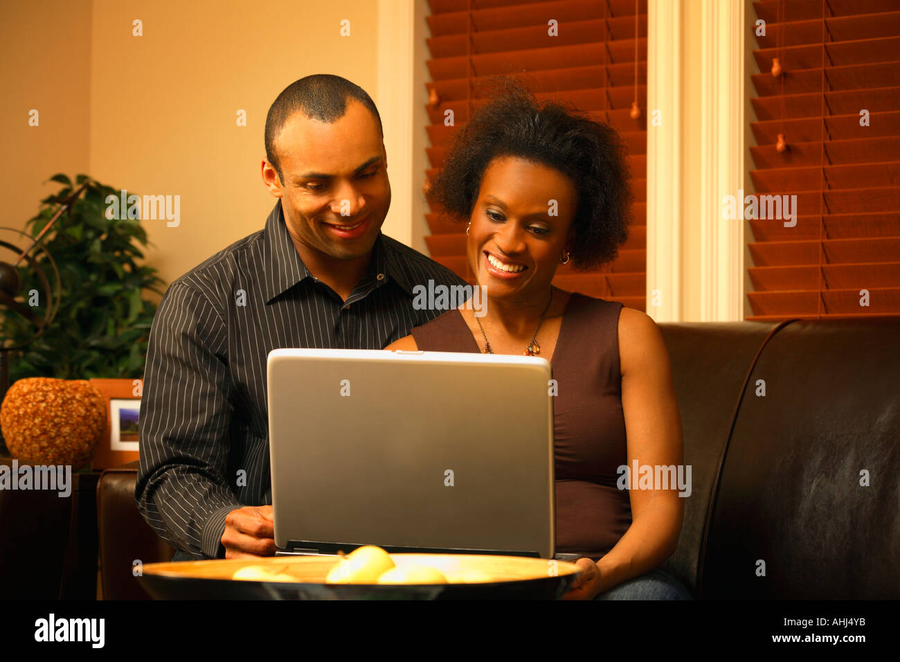 A couple views a laptop together Stock Photo - Alamy