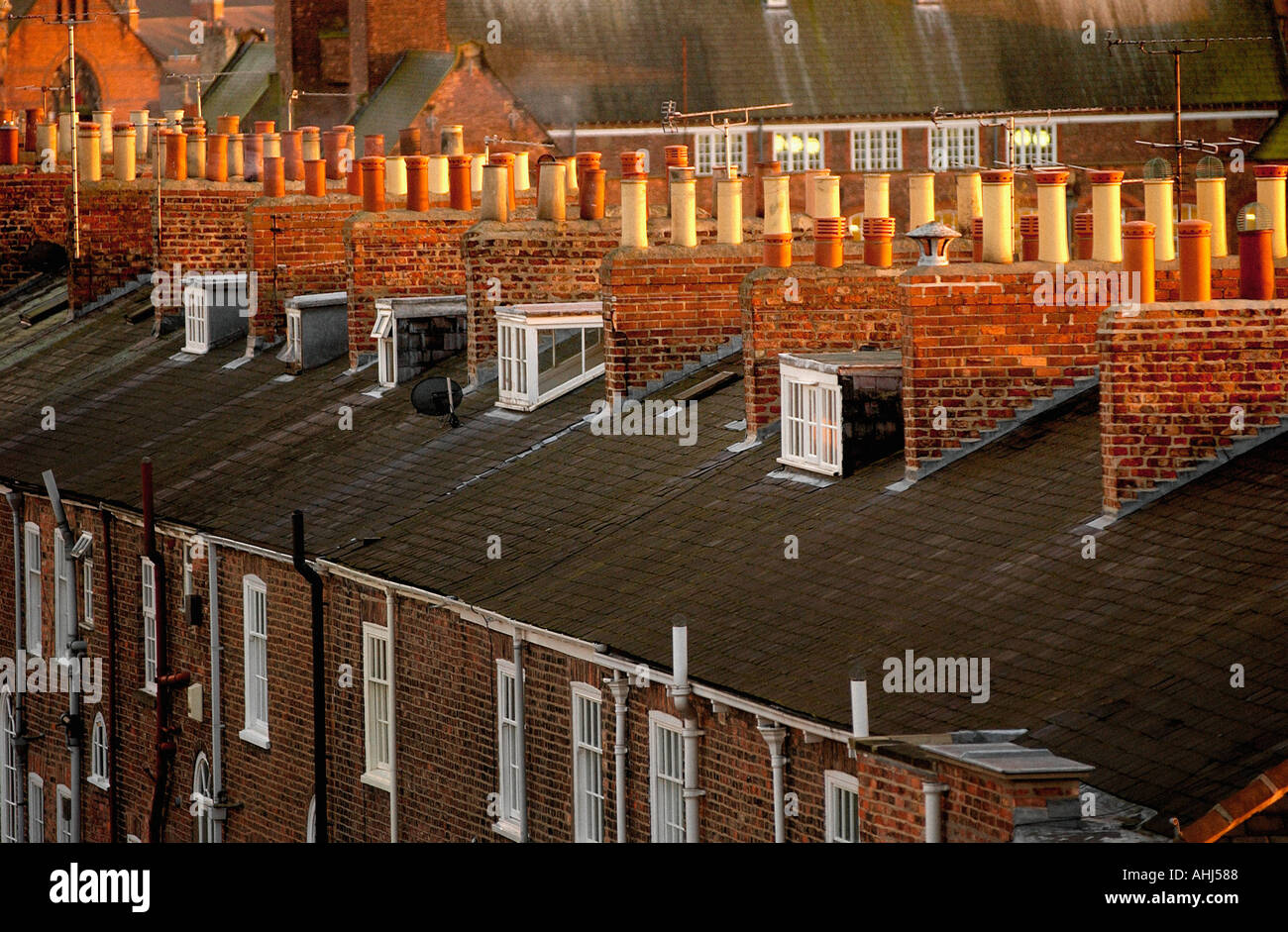 Row of UK terraced town houses with lines of chimney pots on roofs ...