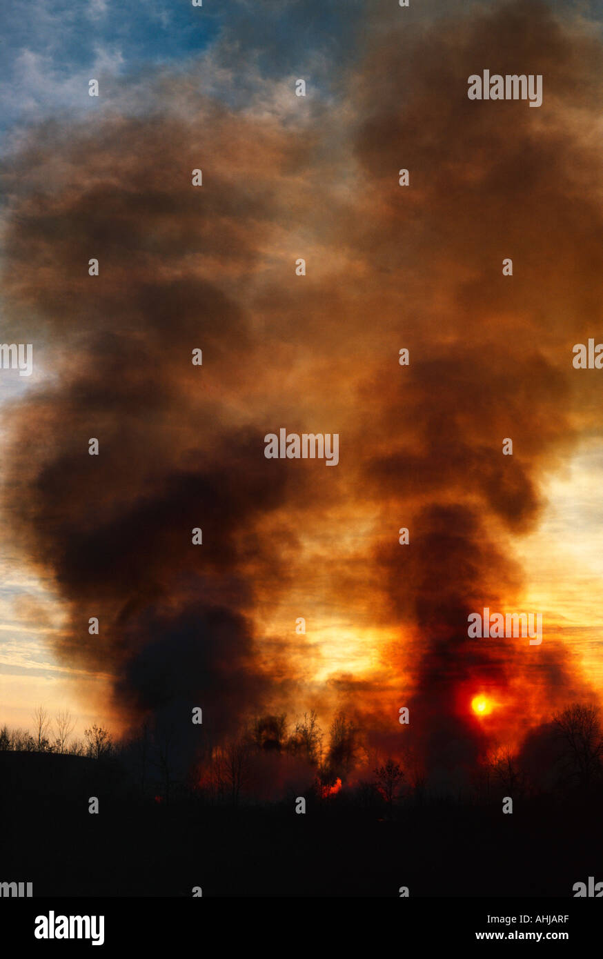 Sunset behind columns of smoke Stock Photo - Alamy