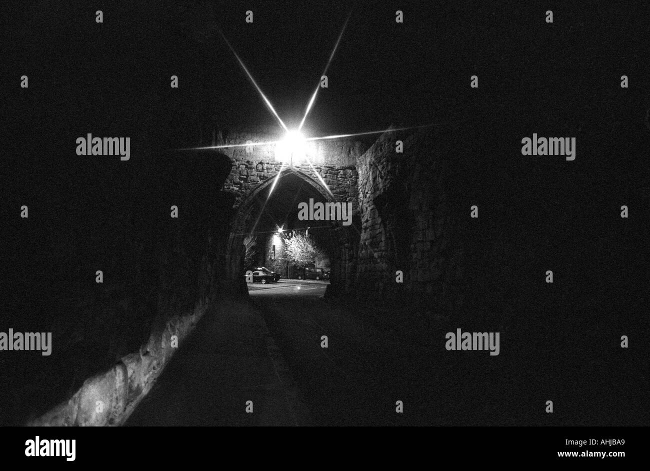 Road passing between ancient stone walls and under archway of The Pends ...