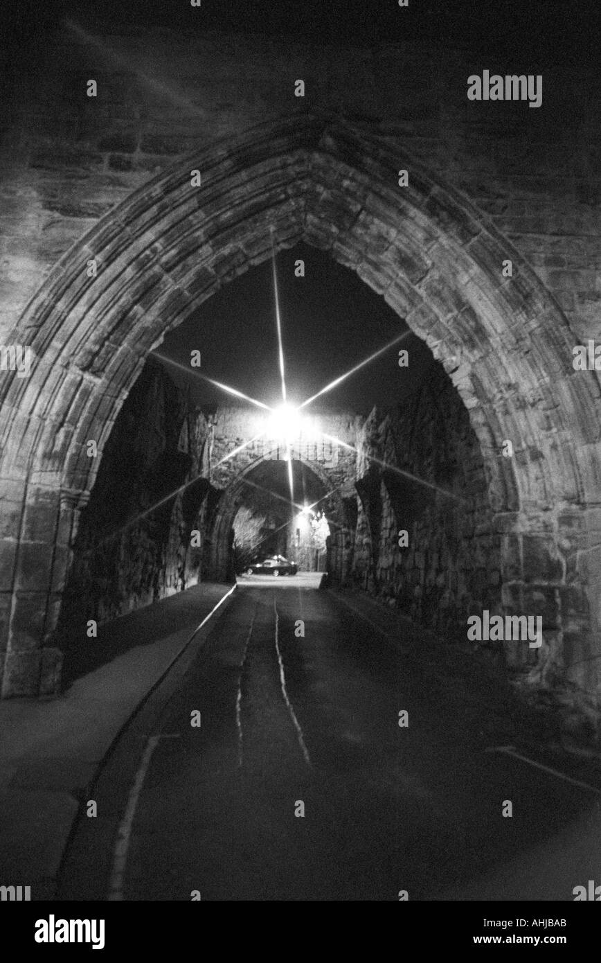 Road passing between ancient stone walls and under archway of The Pends ...