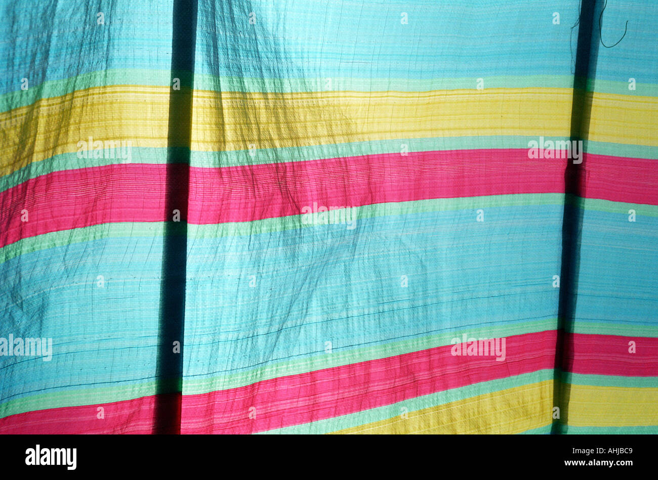 Brightly coloured blue, yellow, red and green windbreak with sun ...