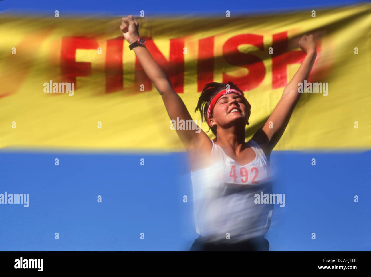 woman runner crossing finish line at track meet Stock Photo - Alamy