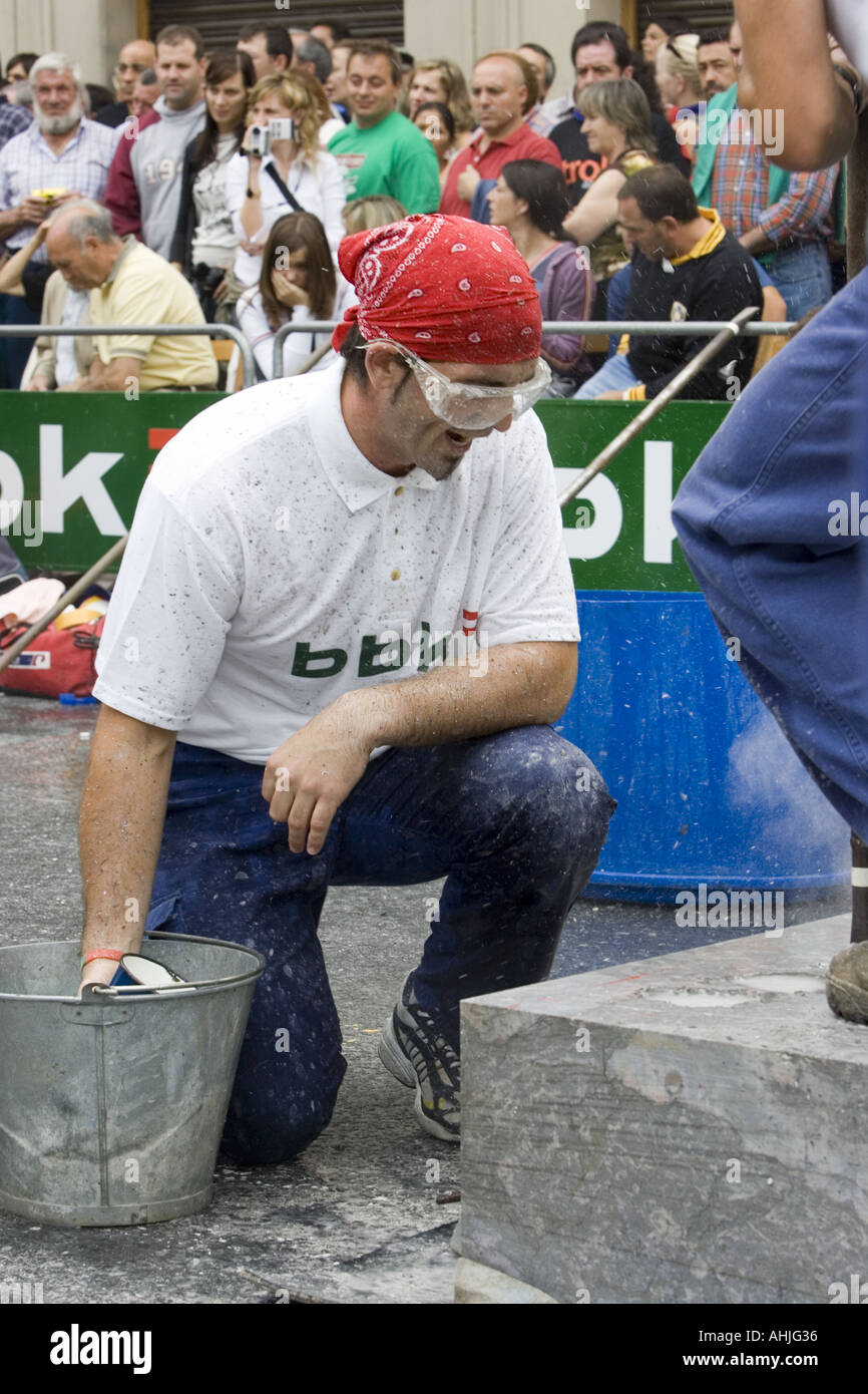 A competitor watches and waits to cool a granite block with water ...