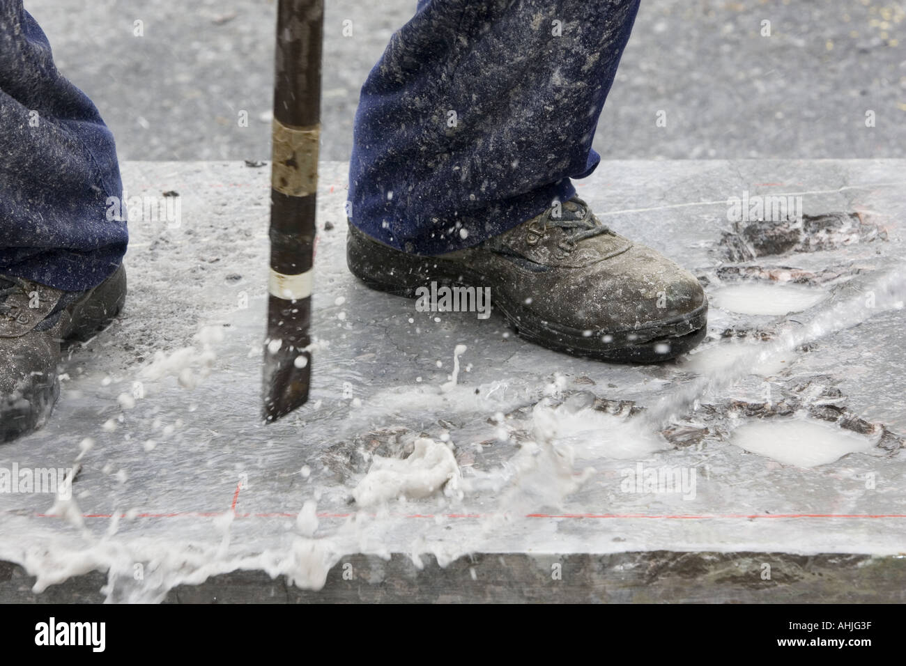 Water splashes in the air as a competitor chips through a granite block ...