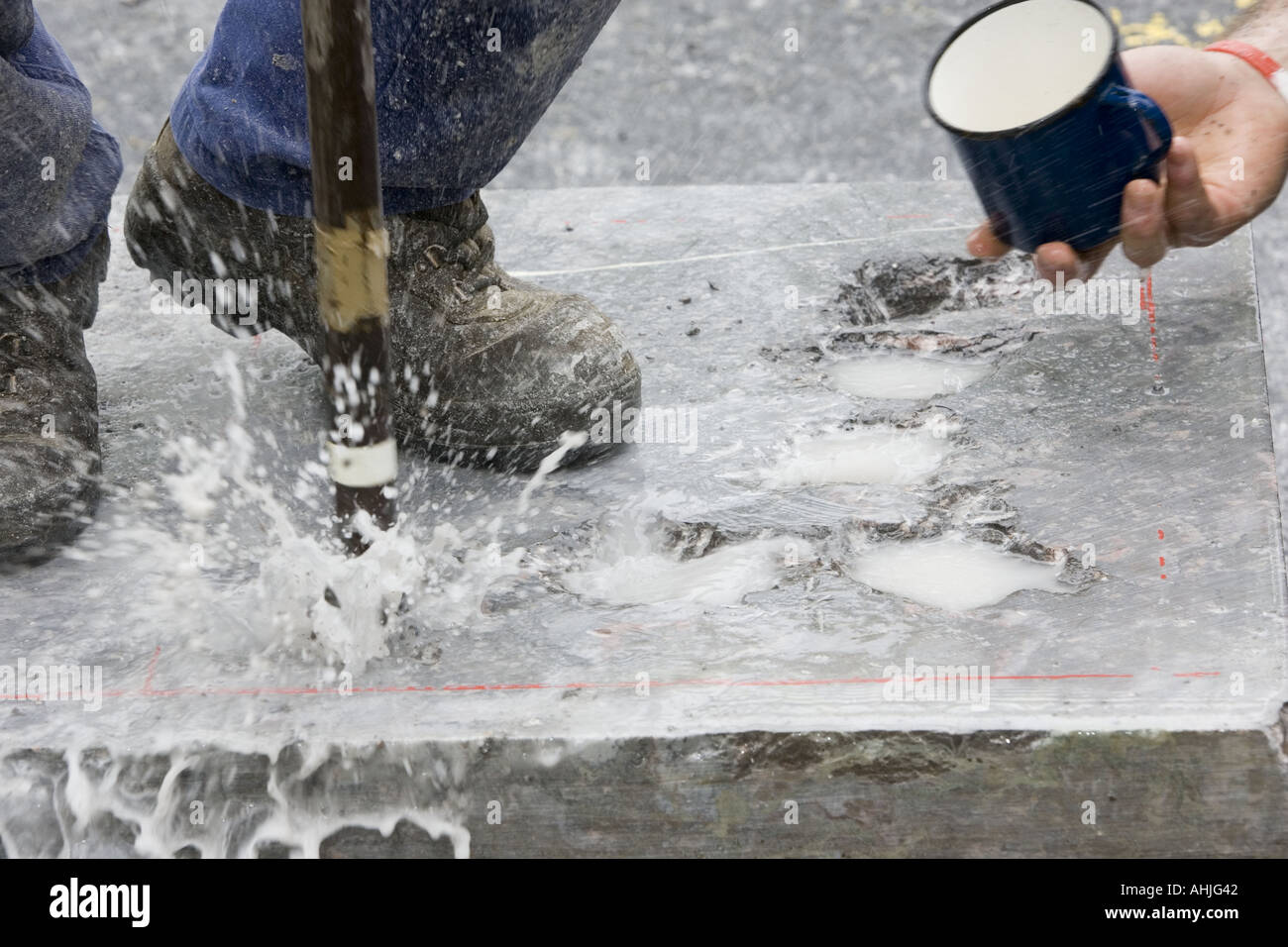 Water splashes in the air as a mug of water is thrown on a block of ...