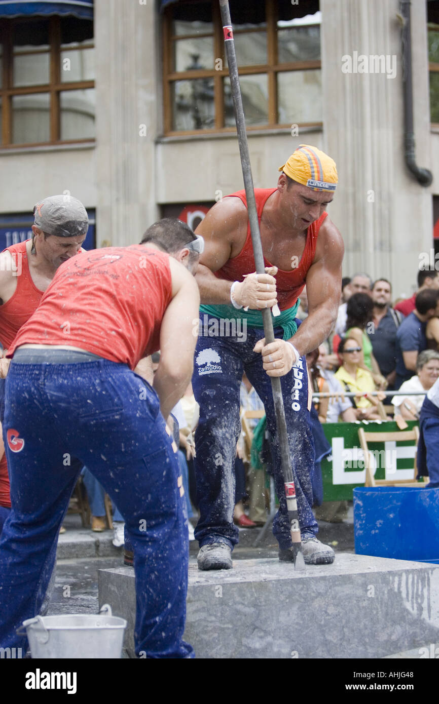 Basque men chipping through a granite block with an iron rod during the ...