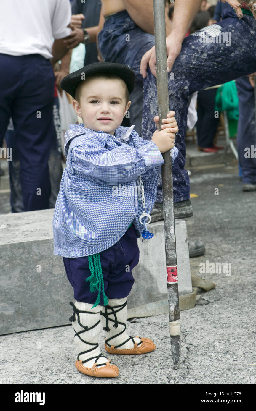 Young child wearing traditional Basque dress holding iron rod during ...