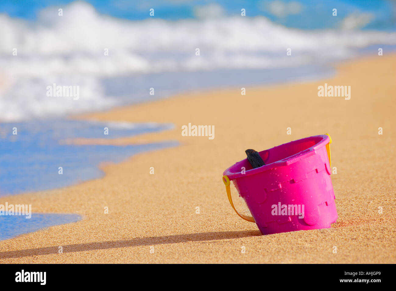 Beach bucket in sand Stock Photo - Alamy