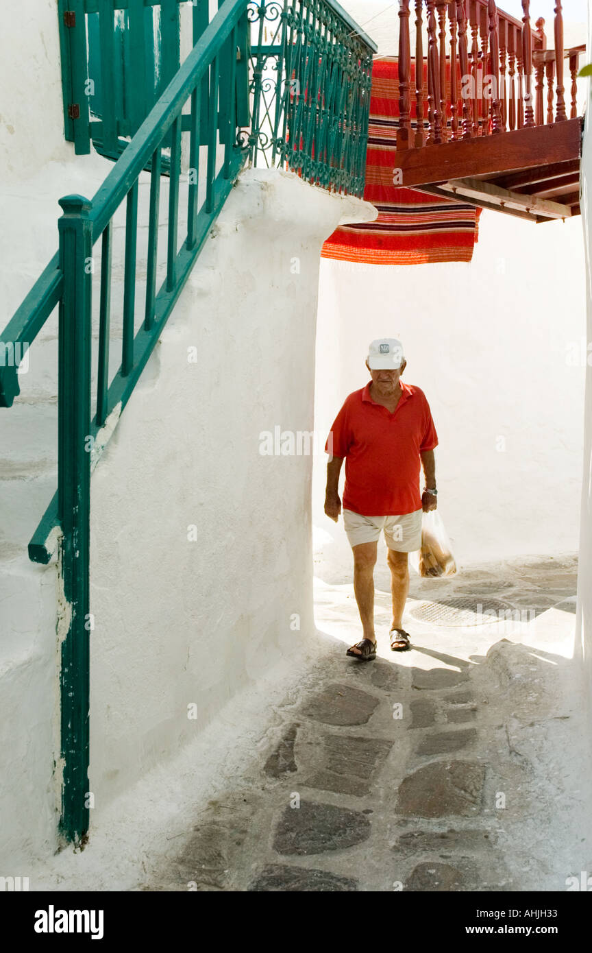 Local Greek man walking shopping in alley alleyway Mykonos Town Mykonos ...