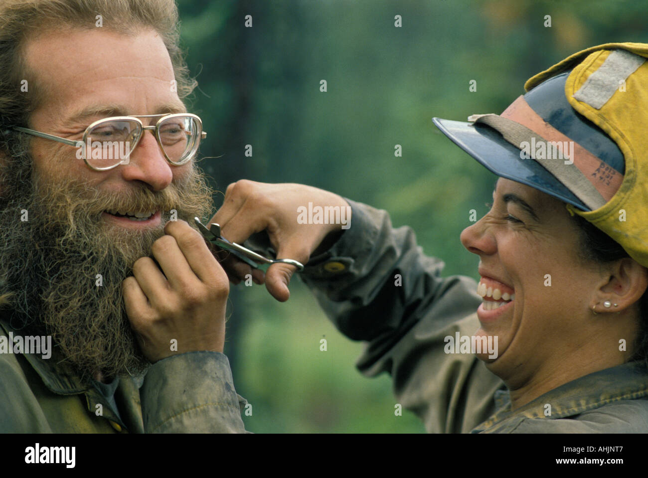 USA Alaska Lake Minchumina Firefighter trims friends beard at camp ...