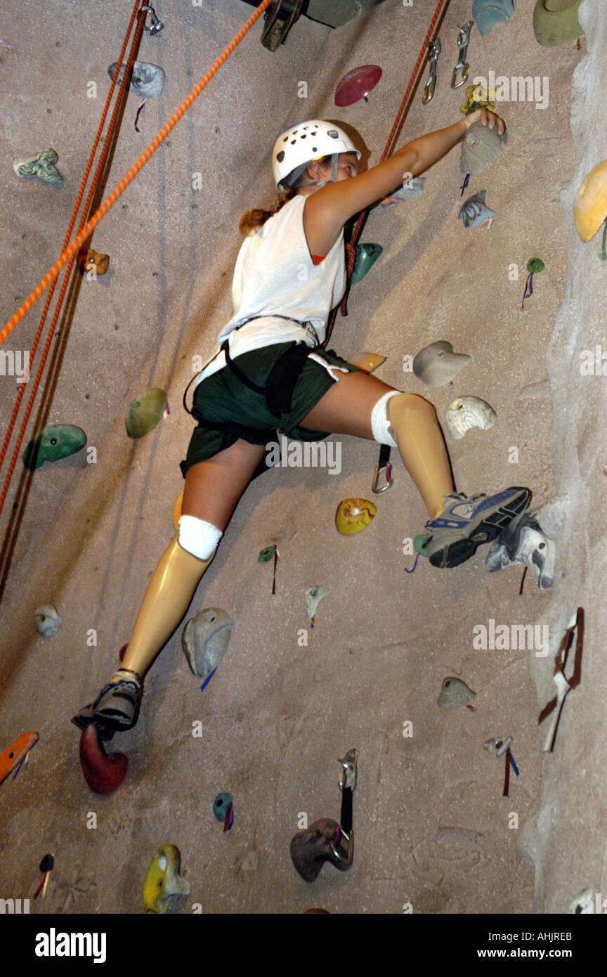 Teen Girl with prosthetic legs climbs indoor rock wall during ...