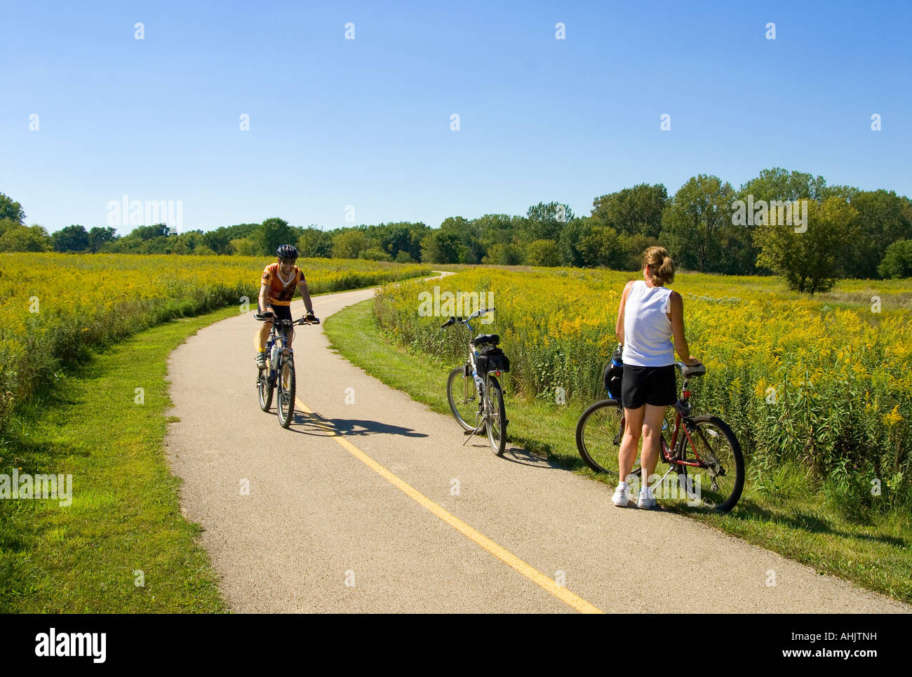 Girl viewing meadow on country bicycle trail Stock Photo - Alamy