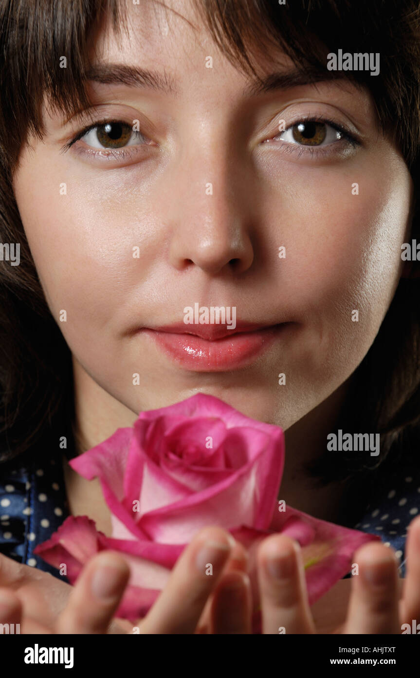 Young woman with a pink rose in her hands Stock Photo - Alamy