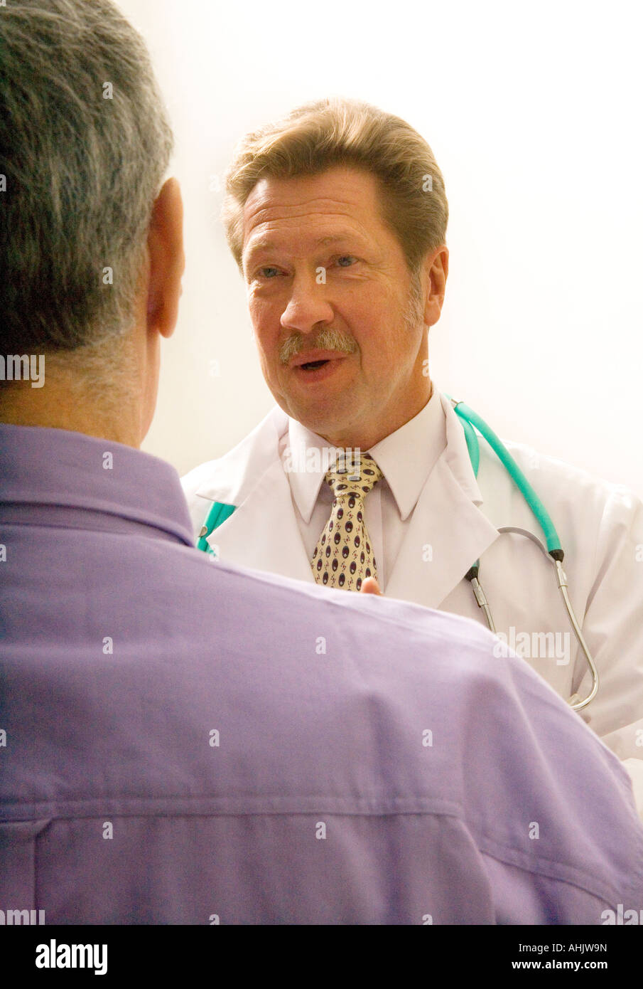 Doctor talking with male patient Stock Photo - Alamy