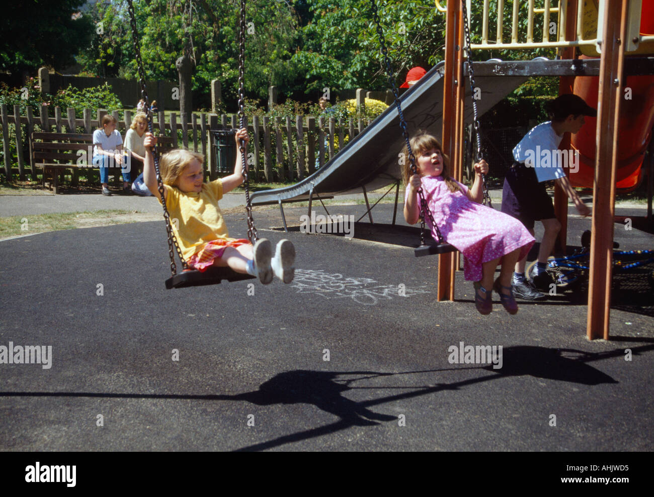 Children In Playground On Swing Stock Photo - Alamy