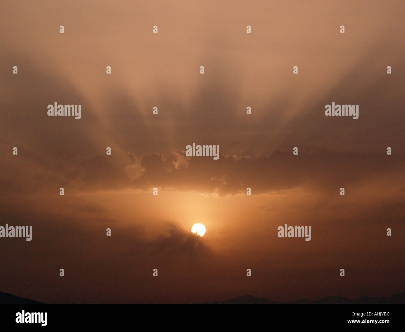 sun rays breaking through clouds at sunset Stock Photo - Alamy