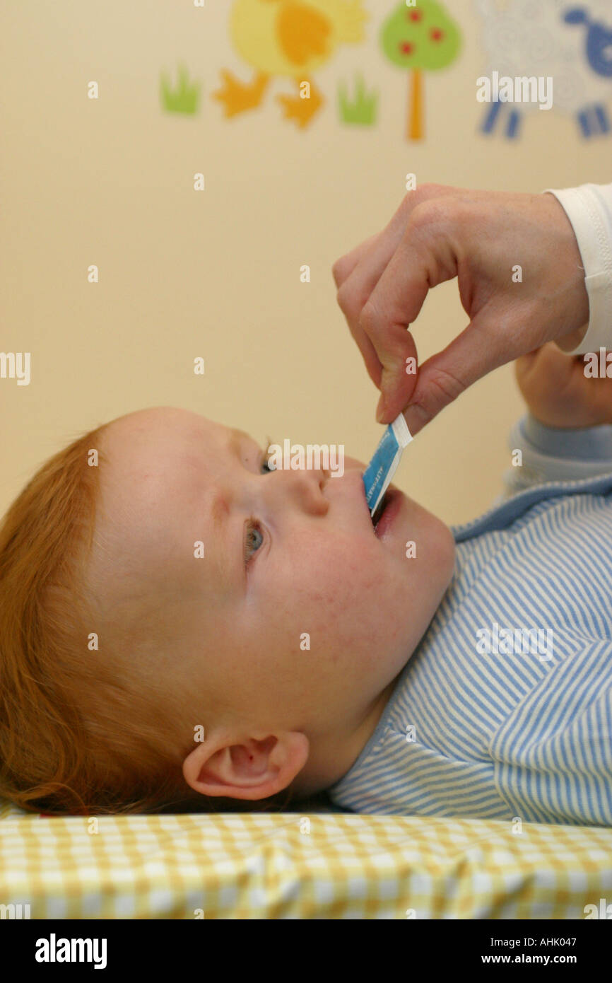 A baby receiving alternative homeopathic medicine to relieve teething ...